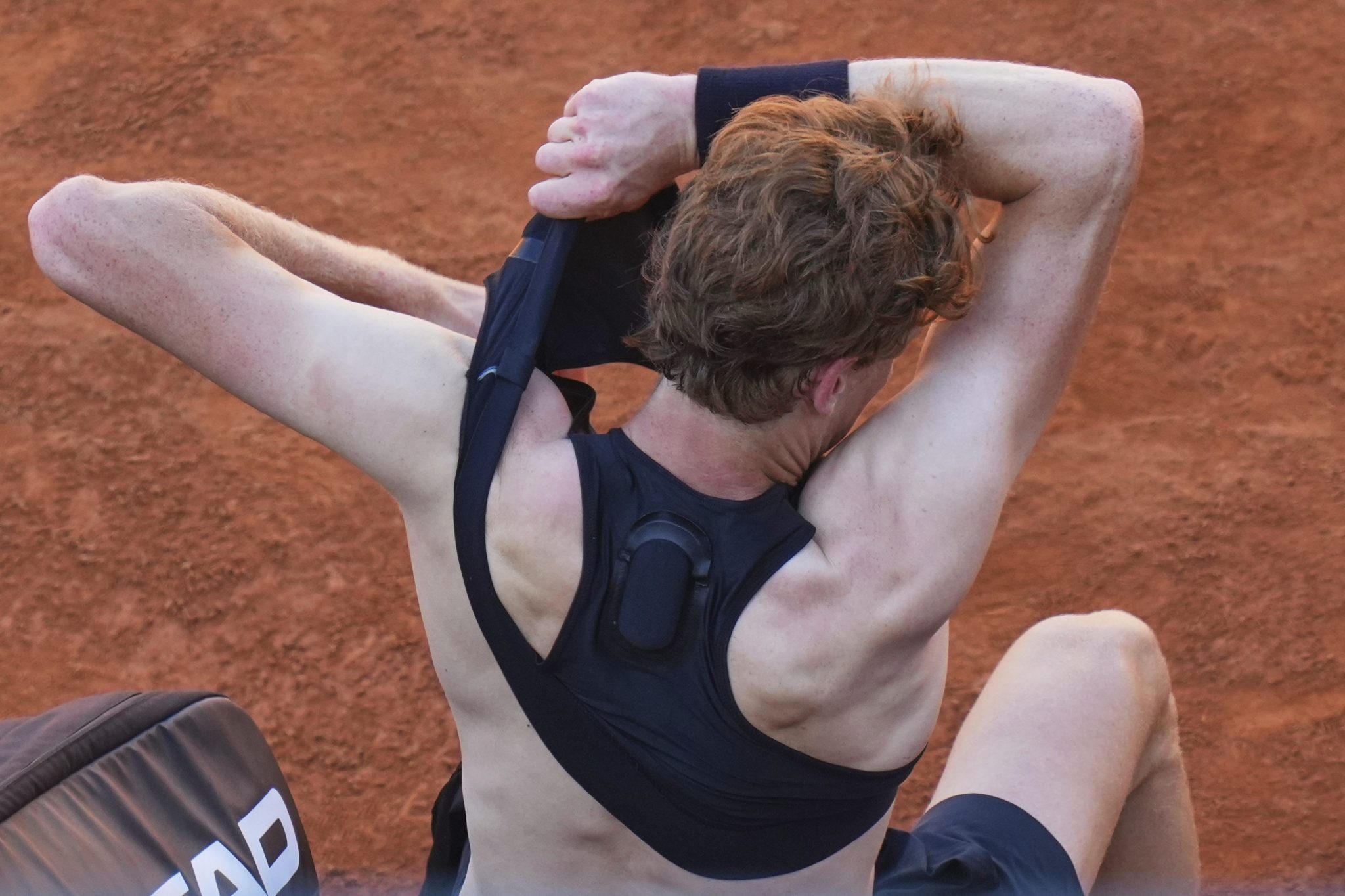 Sinner si spoglia e si toglie il dispositivo che ha sulla schiena ...