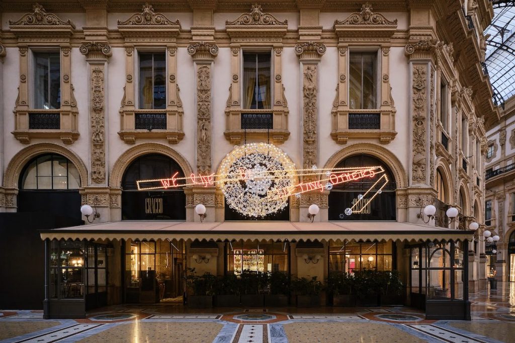 L'insegna del ristorante di Cracco coperta da uno slogan: il significato della scritta luminosa